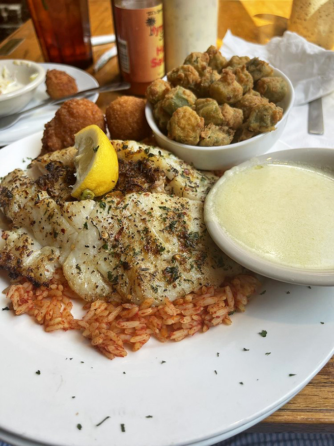 This perfectly seasoned fish rests on a bed of red rice like royalty, with fried okra standing guard and lemon ready for duty.