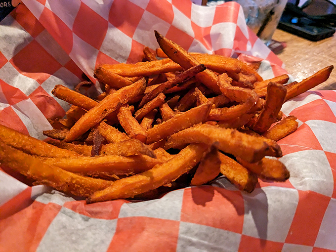 Sweet potato fries that achieve the impossible: crispy exterior, pillowy interior, and that perfect balance of sweet and savory that keeps your hand reaching back.