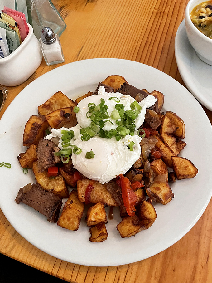 Breakfast alchemy at its finest &ndash; crispy sweet potatoes, savory meat, and those perfectly poached eggs creating the morning gold standard.