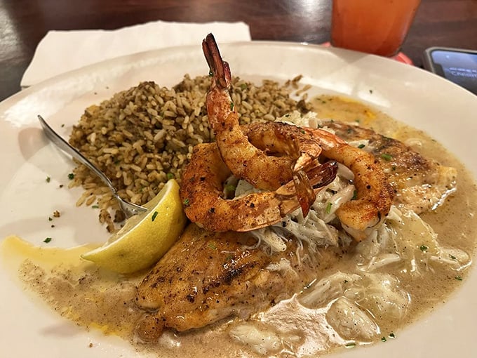 Texas Redfish Pontchartrain swimming in creamy sauce with plump shrimp standing guard&mdash;proof that fish can indeed fly to flavor heaven.