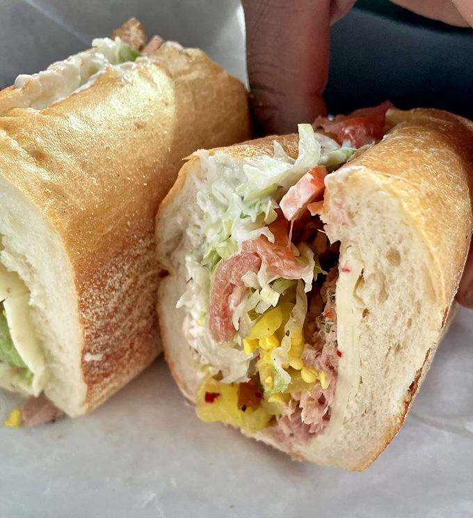 Cross-section perfection reveals the careful construction&mdash;each ingredient playing its part in the sandwich symphony, with pickled peppers providing the high notes.