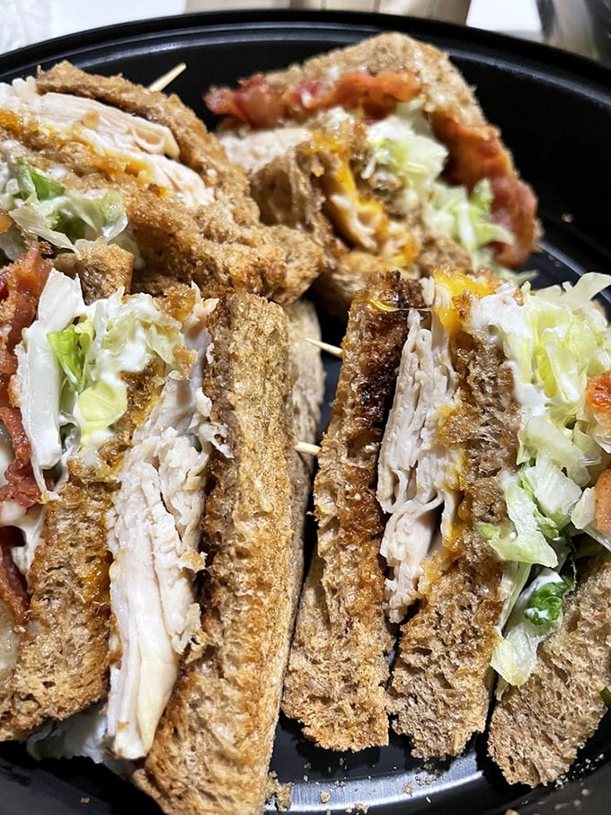 The club sandwich, reinvented: layers of turkey, crisp vegetables, and toasted bread create the skyscraper of sandwiches that's worth every precarious bite.