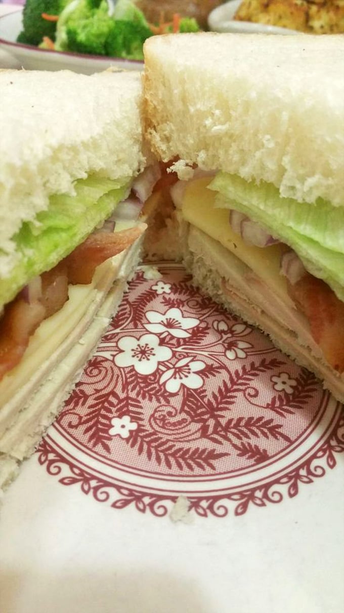 This isn't just a sandwich&mdash;it's architectural achievement with layers of deli meat, cheese, and fresh veggies on pillowy white bread. No tweezers required.