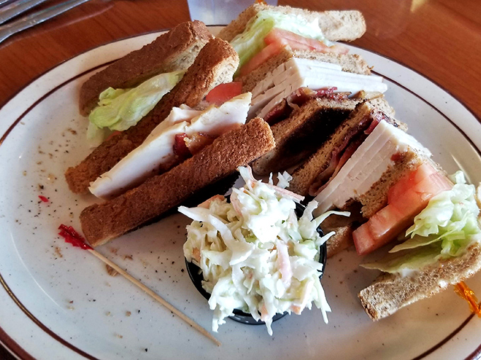 This club sandwich isn't just stacked &ndash; it's architecturally sound. Layers of turkey, crisp lettuce, and tomato with a side of creamy coleslaw that deserves its own fan club.