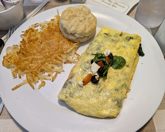 This omelet isn't just folded eggs&mdash;it's a vegetable treasure chest with perfectly crispy hash browns and a biscuit that's practically begging for butter.