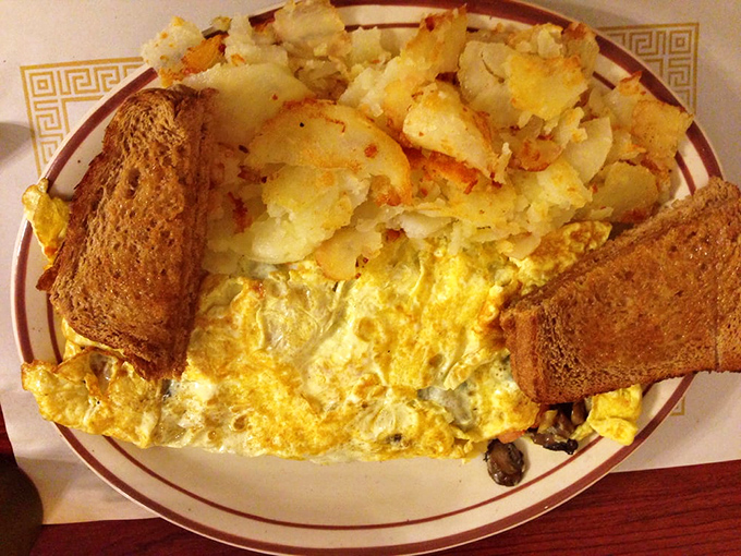 This isn't just an omelet&mdash;it's a golden canvas of eggs cradling melted cheese with home fries that could make a potato farmer weep with joy.