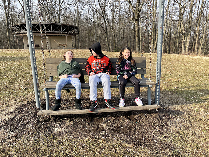 The simple joy of a park bench swing &ndash; where conversations flow, memories are made, and kids pretend they're not having fun with their parents.