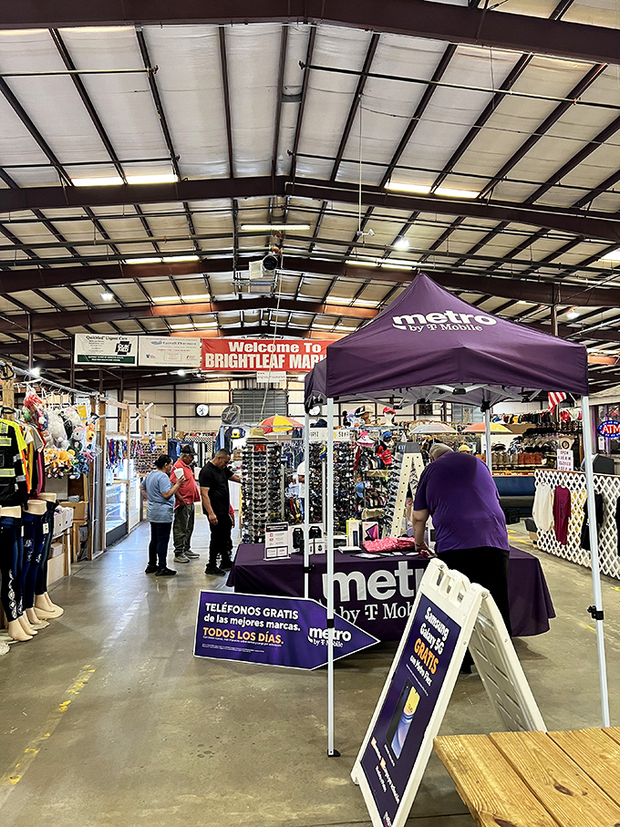 Weekend warriors navigate the market's maze, where a purple Metro by T-Mobile tent stands like a corporate island in a sea of individuality.