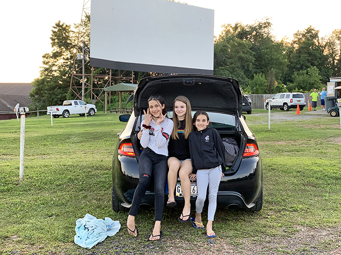 The modern drive-in tailgate: Where teenagers perfect the art of hanging out while parents pretend they came just for the movie.