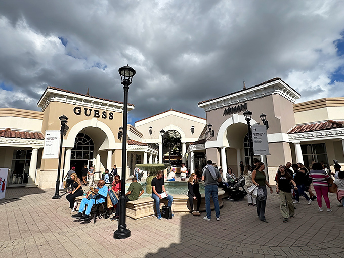 The central courtyard buzzes with bargain hunters taking a breather between shops, proving that outlet shopping is as much social event as sport.