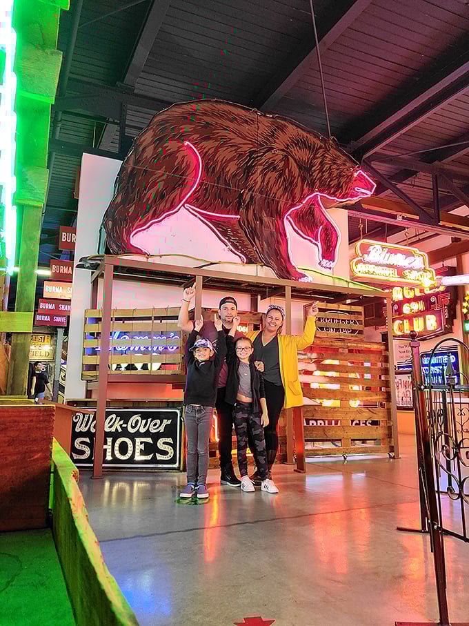 Family memories made under the glow of a giant neon bear. These illuminated treasures connect generations through shared American experiences.