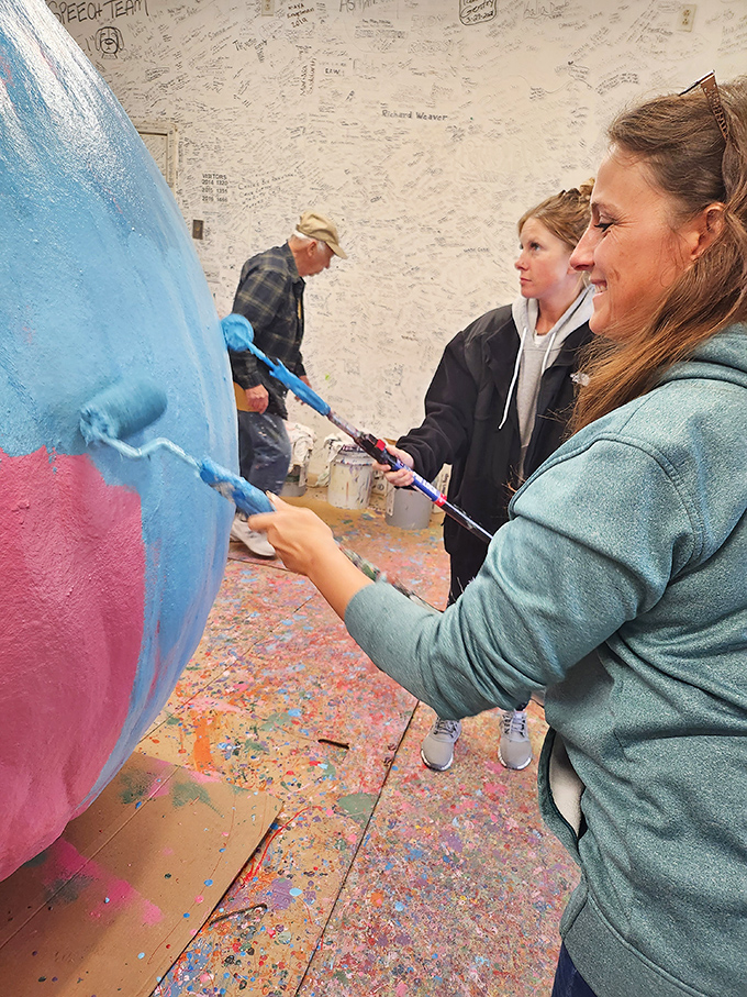 The painting process is a communal affair. Visitors become artists, contributing their brushstrokes to this decades-long masterpiece.