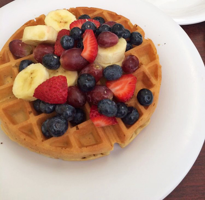 A Belgian waffle that's dressed for success with nature's candy—fresh berries and bananas creating a breakfast that's both virtuous and indulgent.