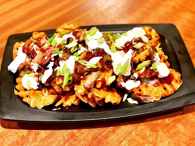 Waffle fry nachos that defy gravity and good sense &ndash; a mountain of crispy potatoes, pulled pork, and sauces that somehow manages to disappear mysteriously fast.