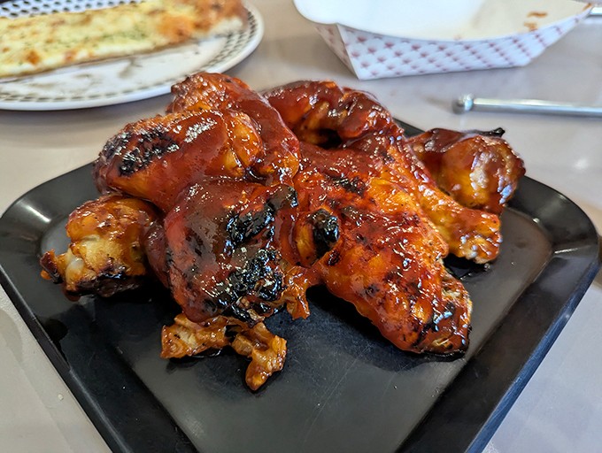 These aren't your average sports bar wings. Caramelized, charred, and glistening with sauce&mdash;they've clearly been introduced to fire the proper way.