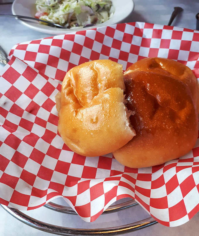 These aren't just dinner rolls&mdash;they're pillowy vessels of joy served on classic red-and-white checkered paper. Resistance is futile.
