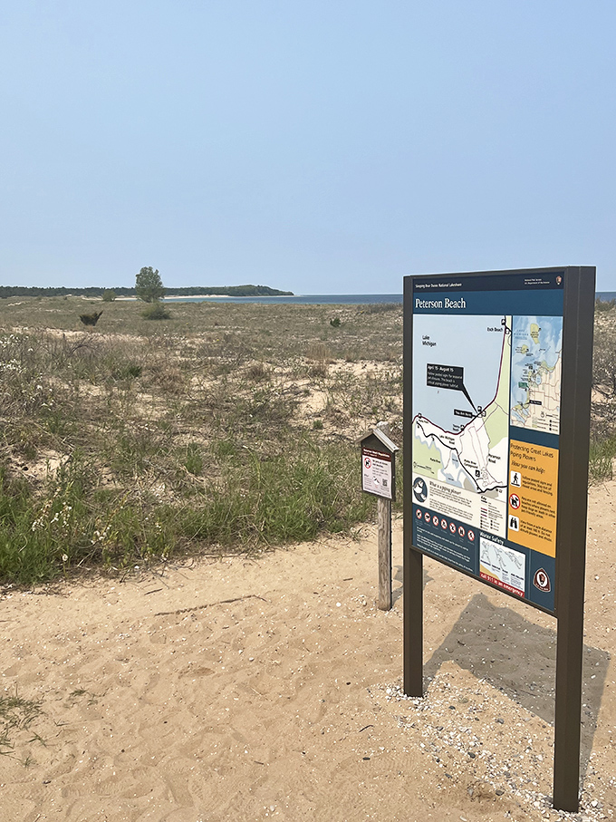 The informational signboard stands sentinel, offering wisdom about this slice of paradise while the vast lake shimmers in the background.