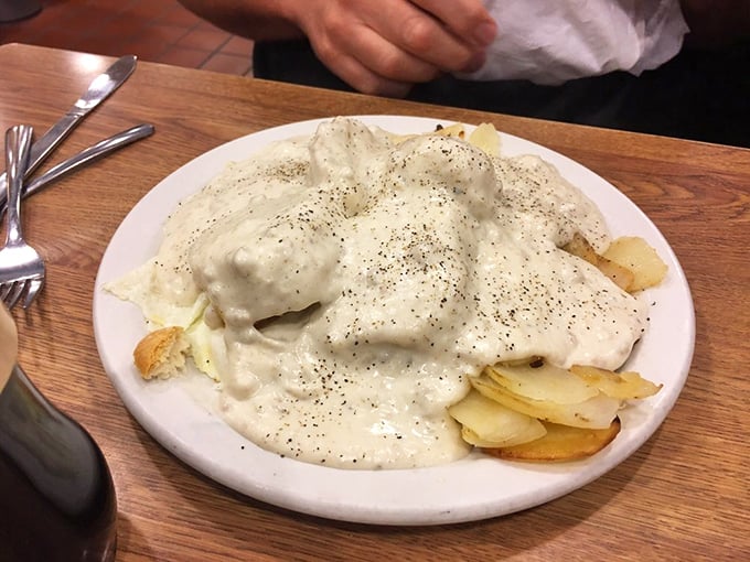 This isn't just biscuits and gravy &ndash; it's a cloud of dough baptized in creamy sausage salvation. The black pepper specks are there to remind you you're still alive.