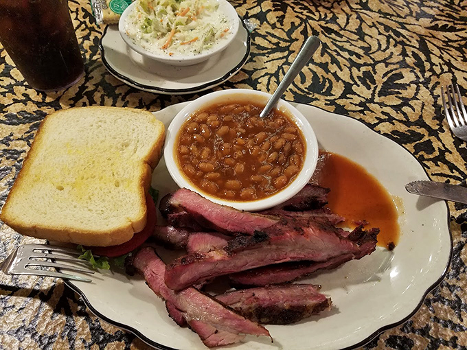 Sliced barbecue beef arrives with beans and bread, creating the holy trinity of Missouri comfort food on one plate.
