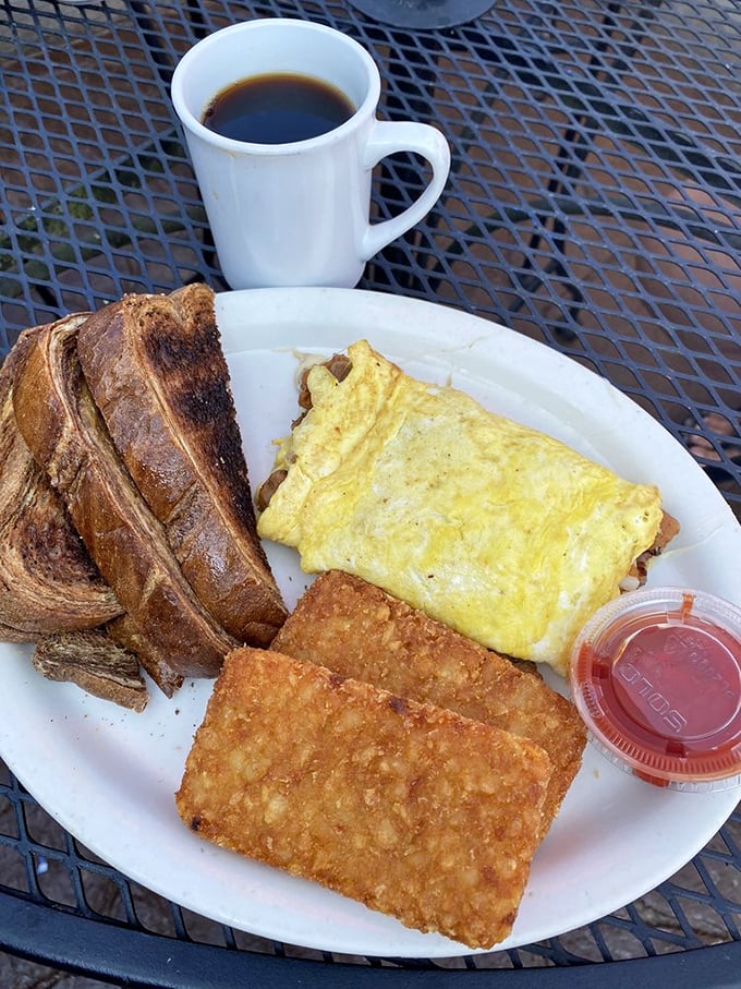 The breakfast trinity: perfectly folded omelet, crispy hash browns, and toast the color of a Midwestern summer sunset. Add coffee and solve world problems.