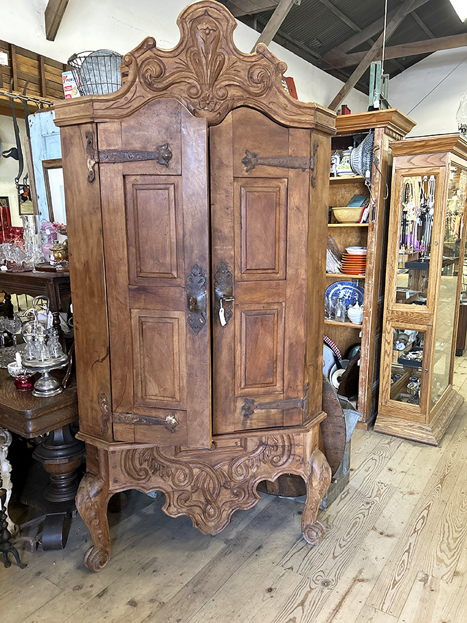 Not just a cabinet but a wooden aristocrat with carved flourishes and iron hardware that's survived longer than most modern relationships.