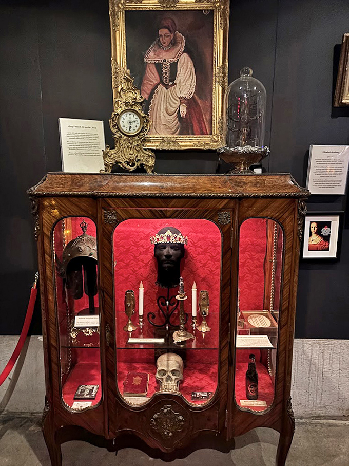 Victorian elegance meets macabre fascination in this ornate display cabinet, where a crowned skull holds court among candles and antiques like a forgotten royal receiving visitors.