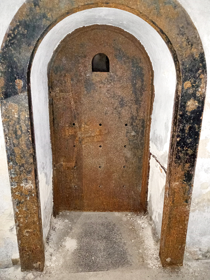 Not your average front door. This heavy cell entrance, studded with metal and featuring serious hardware, wasn't designed for easy exits.