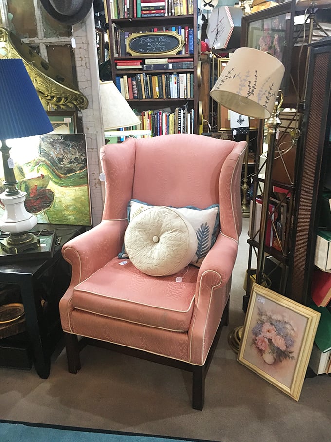 This blush wingback chair isn't just furniture; it's the throne you never knew you needed, surrounded by books that have already lived full lives.