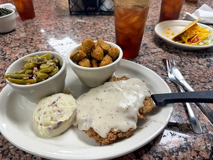 Chicken fried steak wearing its gravy like a tailored suit. Those mashed potatoes could make a grown Texan weep with joy.