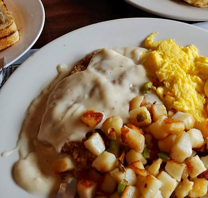 Country-fried steak smothered in creamy gravy alongside golden potatoes and fluffy scrambled eggs. The breakfast trifecta that fuels California's garlic country.