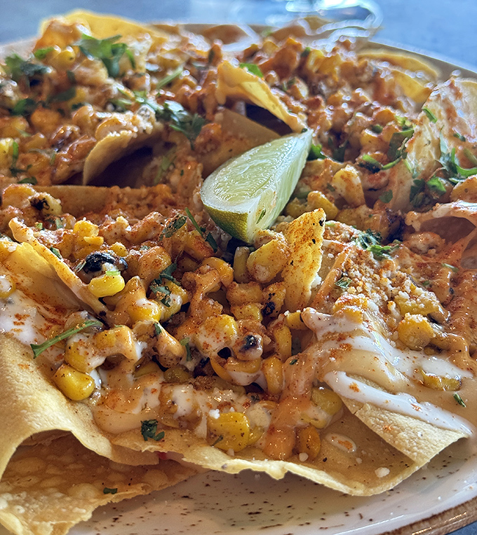 Street corn nachos that put ordinary bar food to shame. That lime wedge isn't just garnish&mdash;it's the conductor of this symphony of flavors.