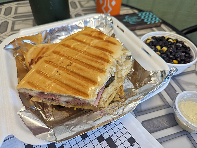 The Cuban sandwich arrives with perfect grill marks that say, "I mean business," while the black bean side dish whispers, "I've got your back."