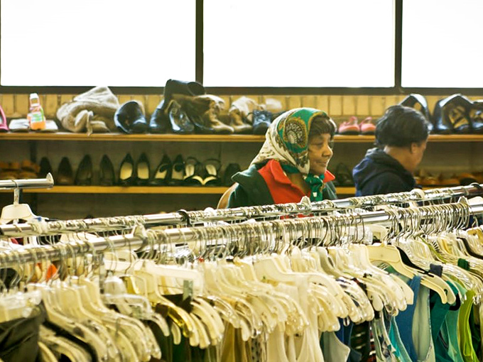 Shoppers navigate the well-organized racks with the focus of archaeologists, each hanger potentially hiding the artifact they've been seeking.
