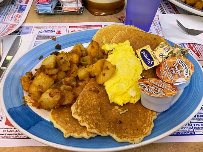 Breakfast perfection on a blue plate: golden pancakes, scrambled eggs, and home fries seasoned to the exact point between "Is that paprika?" and "I need this recipe."