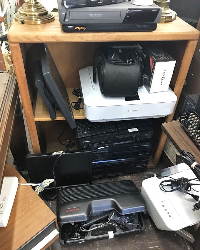 Technology's graveyard or vintage tech heaven? VCRs and printers waiting for their second act or a starring role in a retro movie.