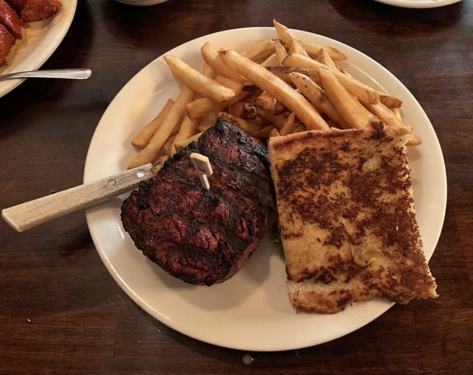 This filet mignon with golden fries and garlic bread makes a stronger case for "happiness on a plate" than any self-help book ever could.