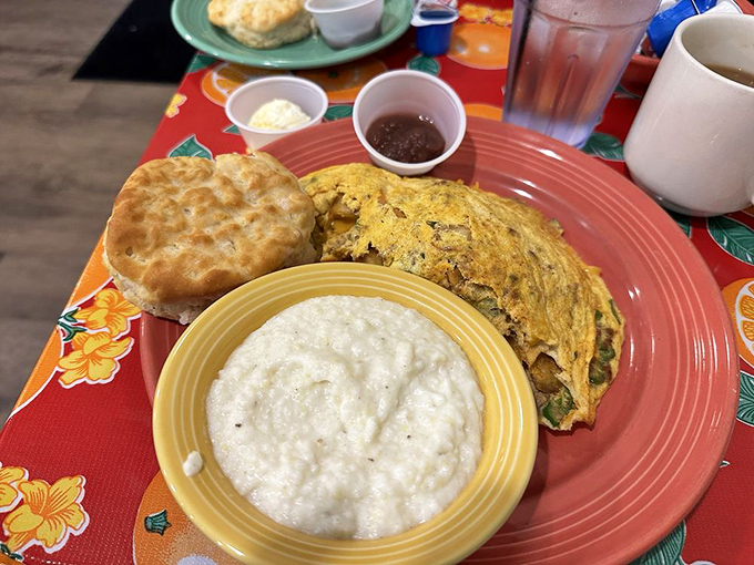 A classic breakfast trinity: golden grits, a perfect biscuit, and an omelet that clearly went to culinary finishing school.