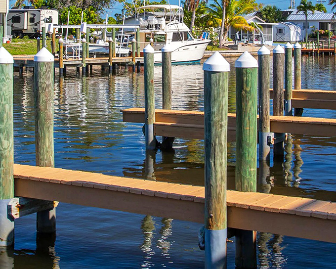 Weathered wooden pilings stand sentinel in calm waters, ready to welcome returning boats after a day of fishing or island exploration.