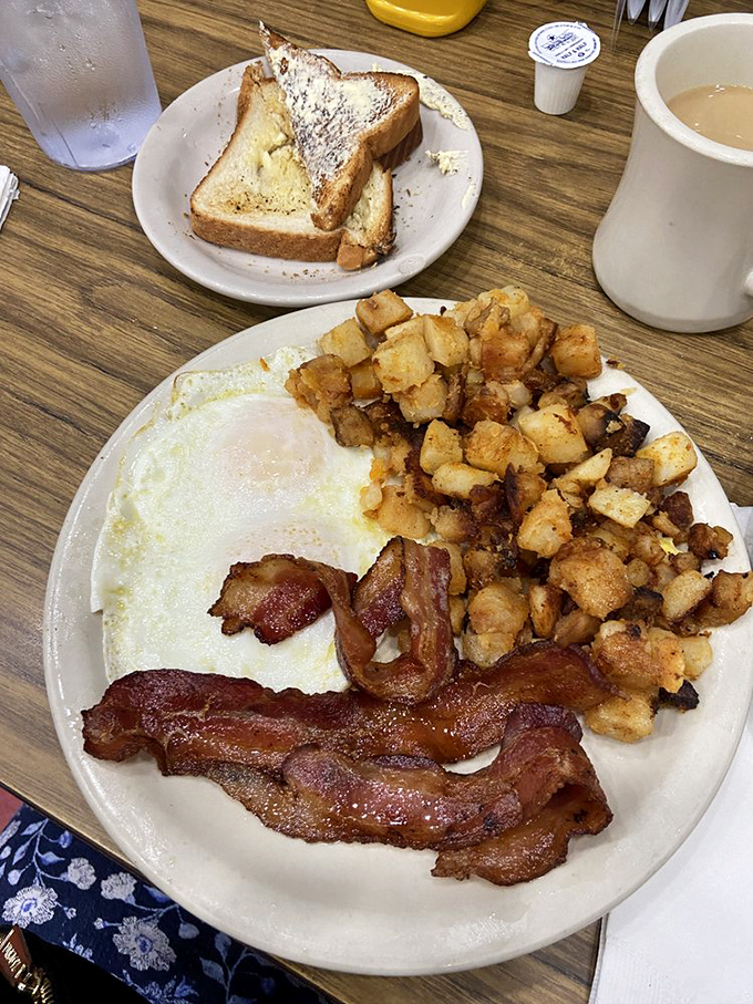 The breakfast trinity: perfectly cooked eggs, bacon with that ideal crisp-to-chew ratio, and home fries that could make a potato proud.