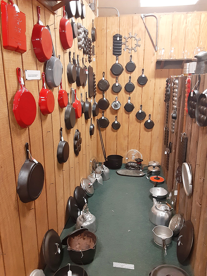 Cast iron heaven where kitchen workhorses hang like trophies, each skillet seasoned with decades of family meals and morning bacon rituals.