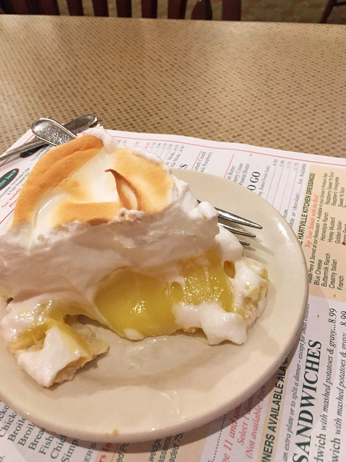 Golden meringue peaks tower over tart lemon filling like edible clouds promising pure dessert heaven below.