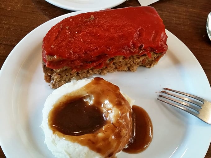 Meatloaf wearing its tomato glaze like a crown, with mashed potatoes standing by for gravy duty. Comfort food that means business.