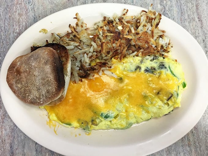 The holy trinity of breakfast: a perfectly folded omelet, crispy-edged home fries, and an English muffin toasted just right.