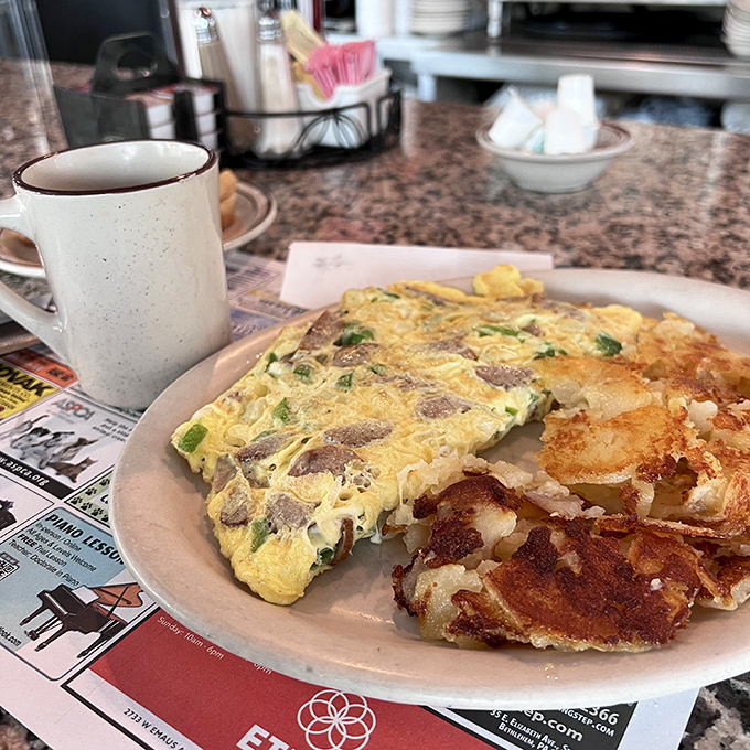 This isn't just an omelet&mdash;it's breakfast architecture. Perfectly folded eggs housing a treasure of fillings, with crispy potatoes standing guard on the side.