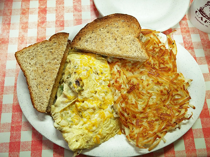 Breakfast architecture at its finest. This omelet defies gravity while those hash browns achieve the perfect crisp-to-tender ratio that science still can't explain.