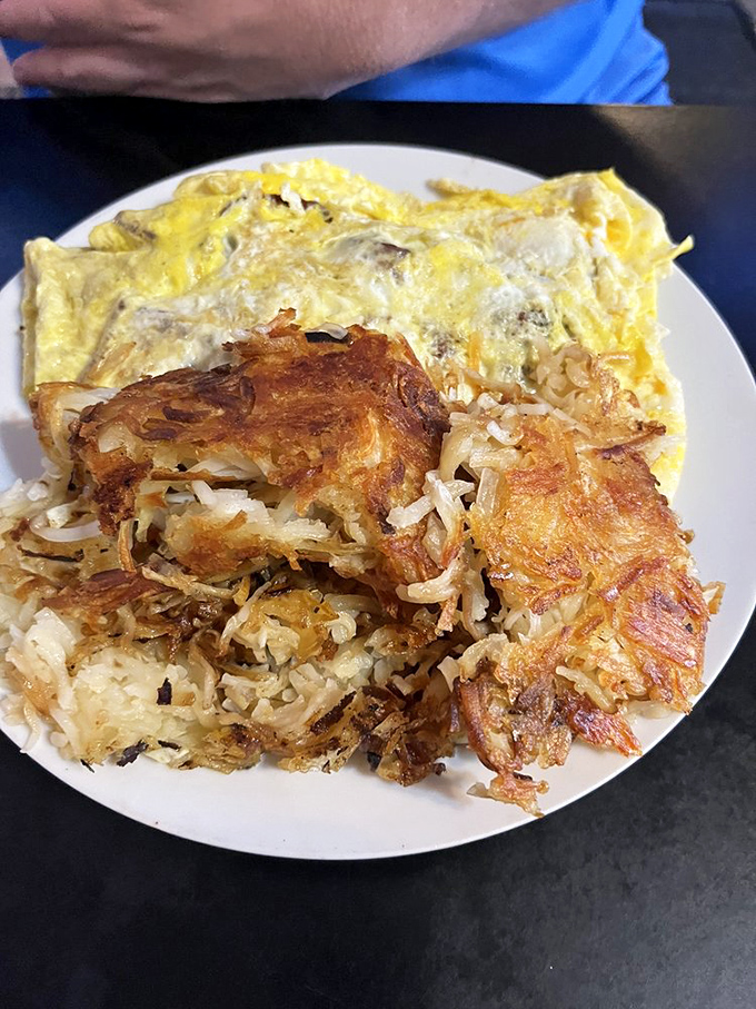 The perfect breakfast trinity: a fluffy omelet, crispy hash browns, and the promise that your day can only get better from here.