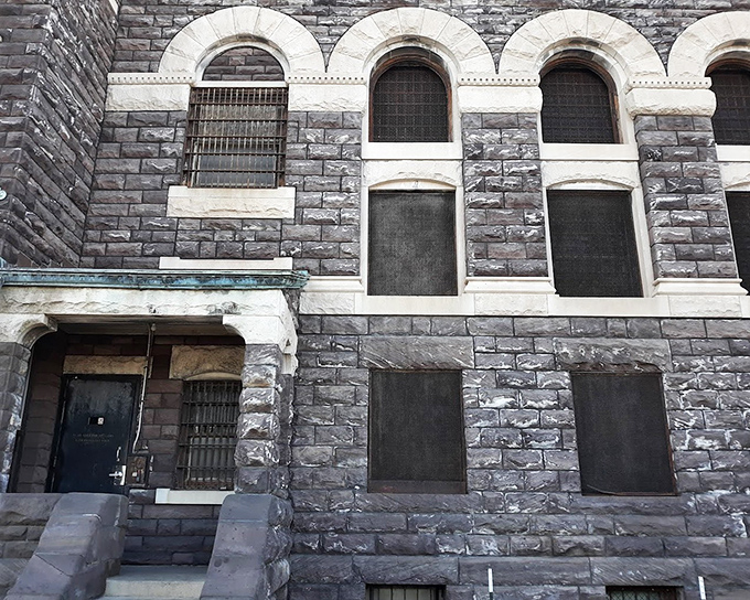 The jail's exterior combines architectural grandeur with unmistakable purpose. Those ornate columns frame a barred entrance that few entered willingly.