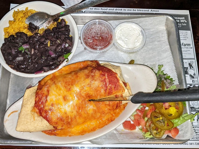 This pulled pork burrito arrives looking like a golden present wrapped in tortilla, accompanied by perfectly seasoned black beans.