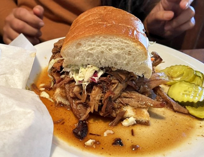 This pulled pork sandwich isn't just a meal; it's an engineering marvel of meat-to-bread ratio that somehow defies gravity and good manners.