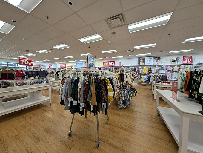 Clothing racks displaying the universal truth of outlet shopping: patience reveals treasures. Those 70% off signs are practically winking at you.